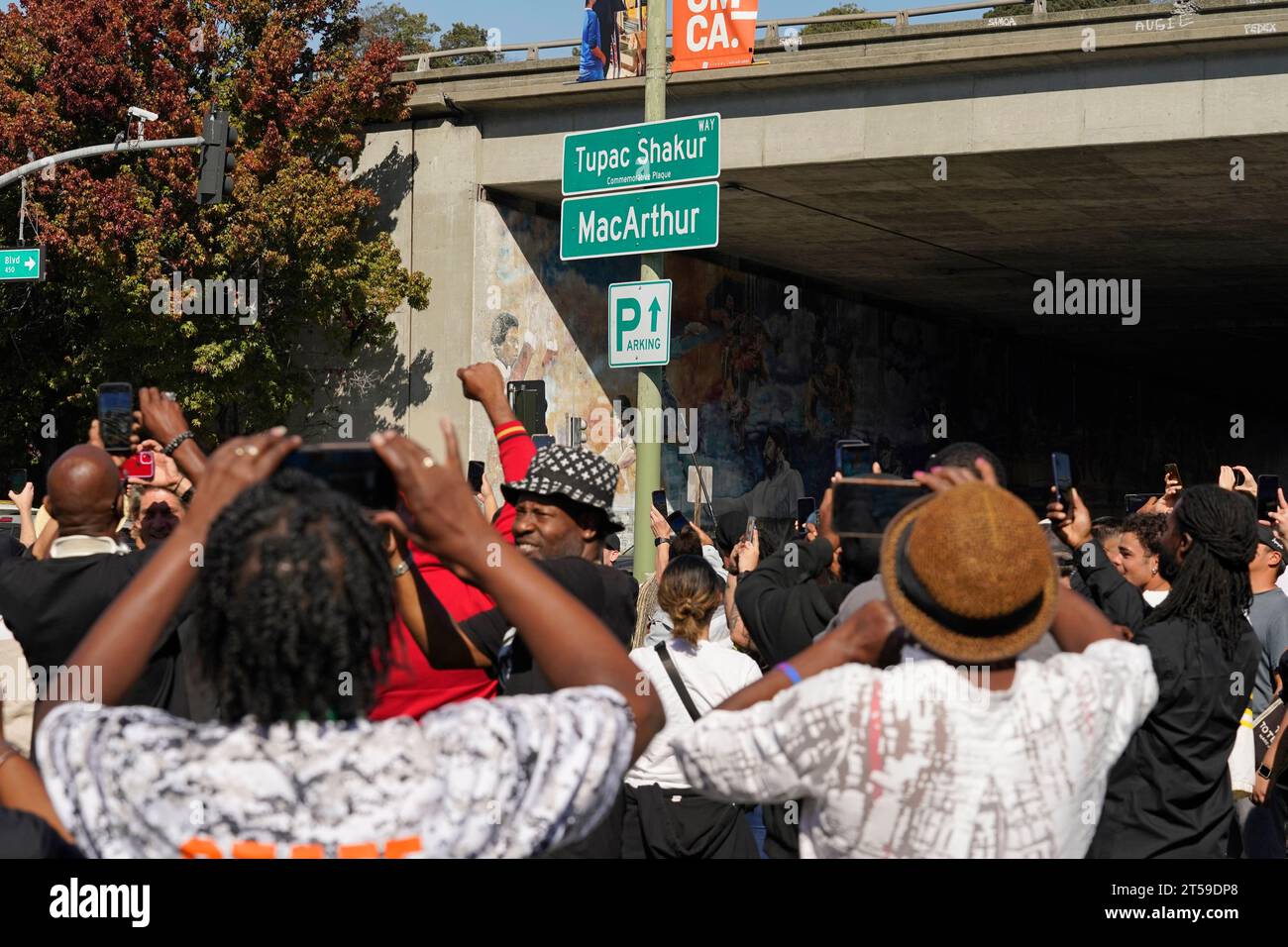 People watch as a new sign is unveiled during a street renaming ...