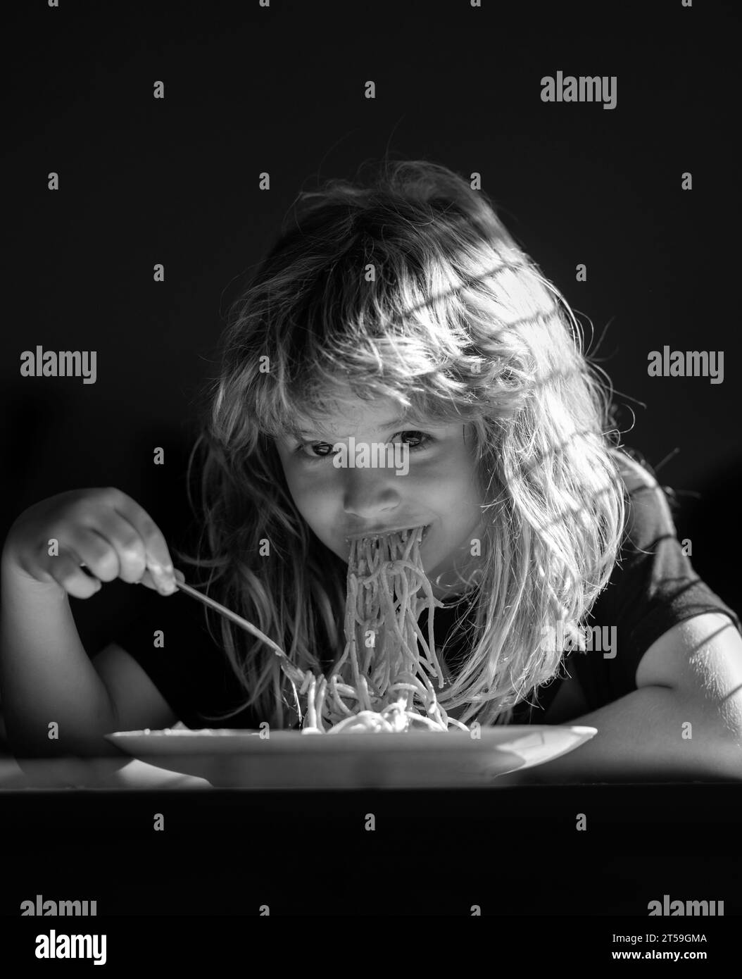 Happy child boy with spoon eats itself. Cute little kid eating ...