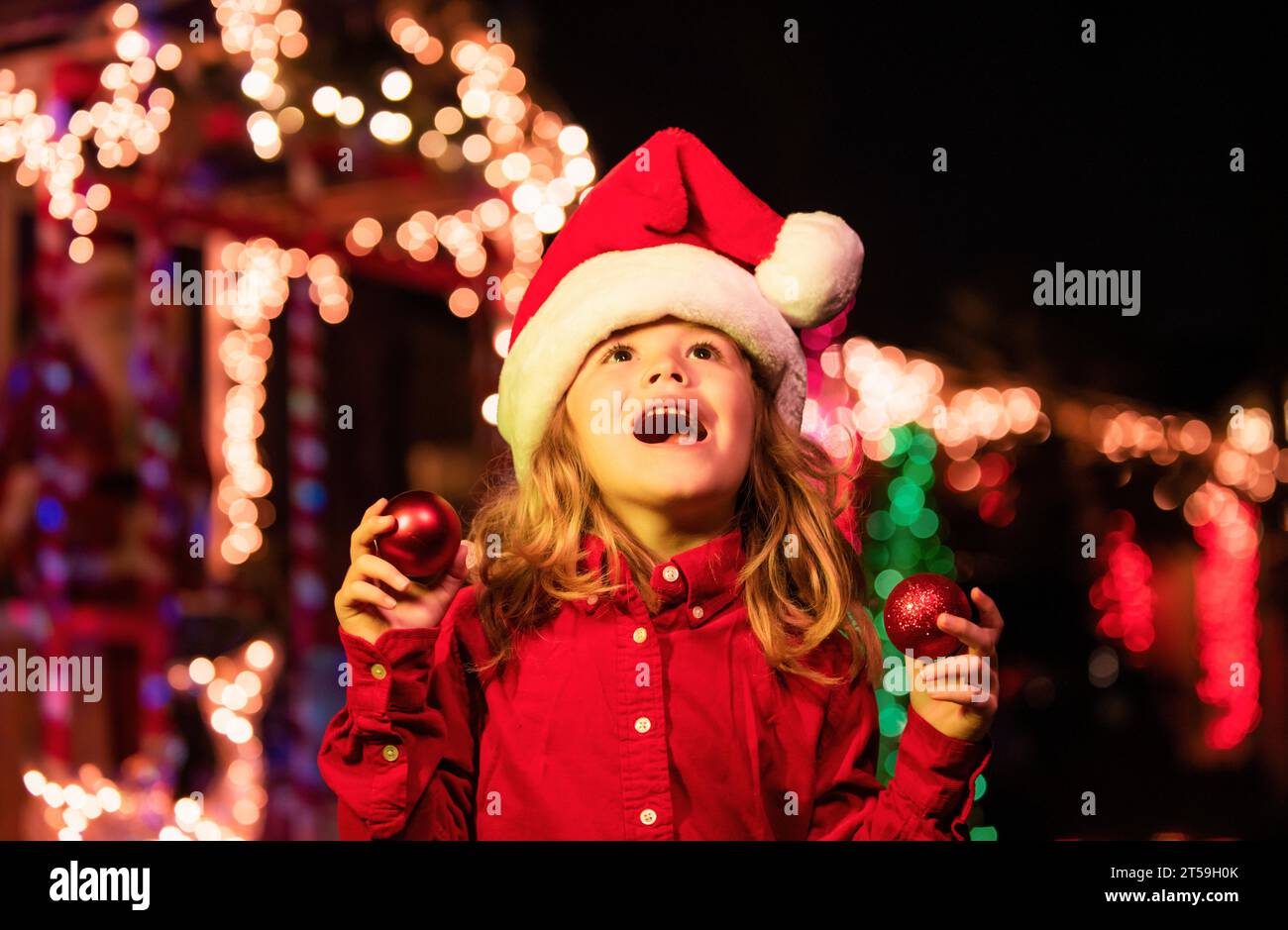 Happy little kid looks at the sky in the Christmas night. Happy kids ...