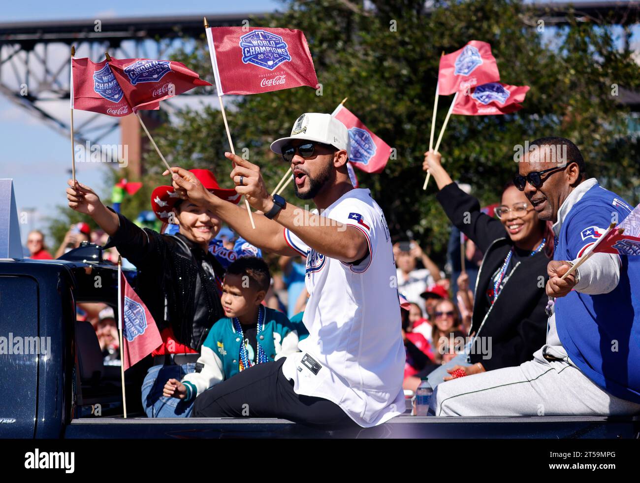 Texas Rangers center fielder Leody Taveras and his family wave flags ...