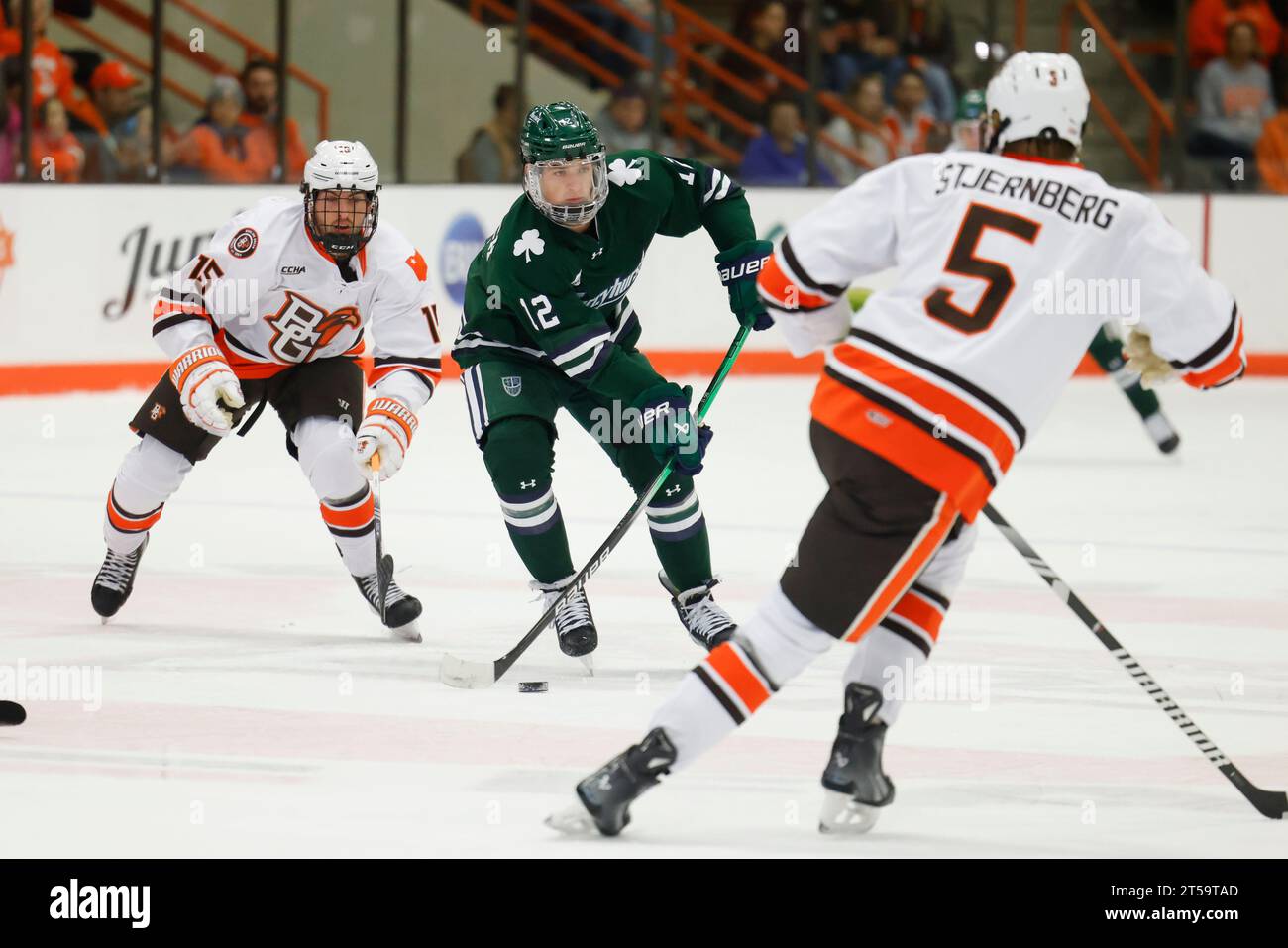 Mercyhurst defenseman Dustin Geregach (12) skates with the puck chased ...