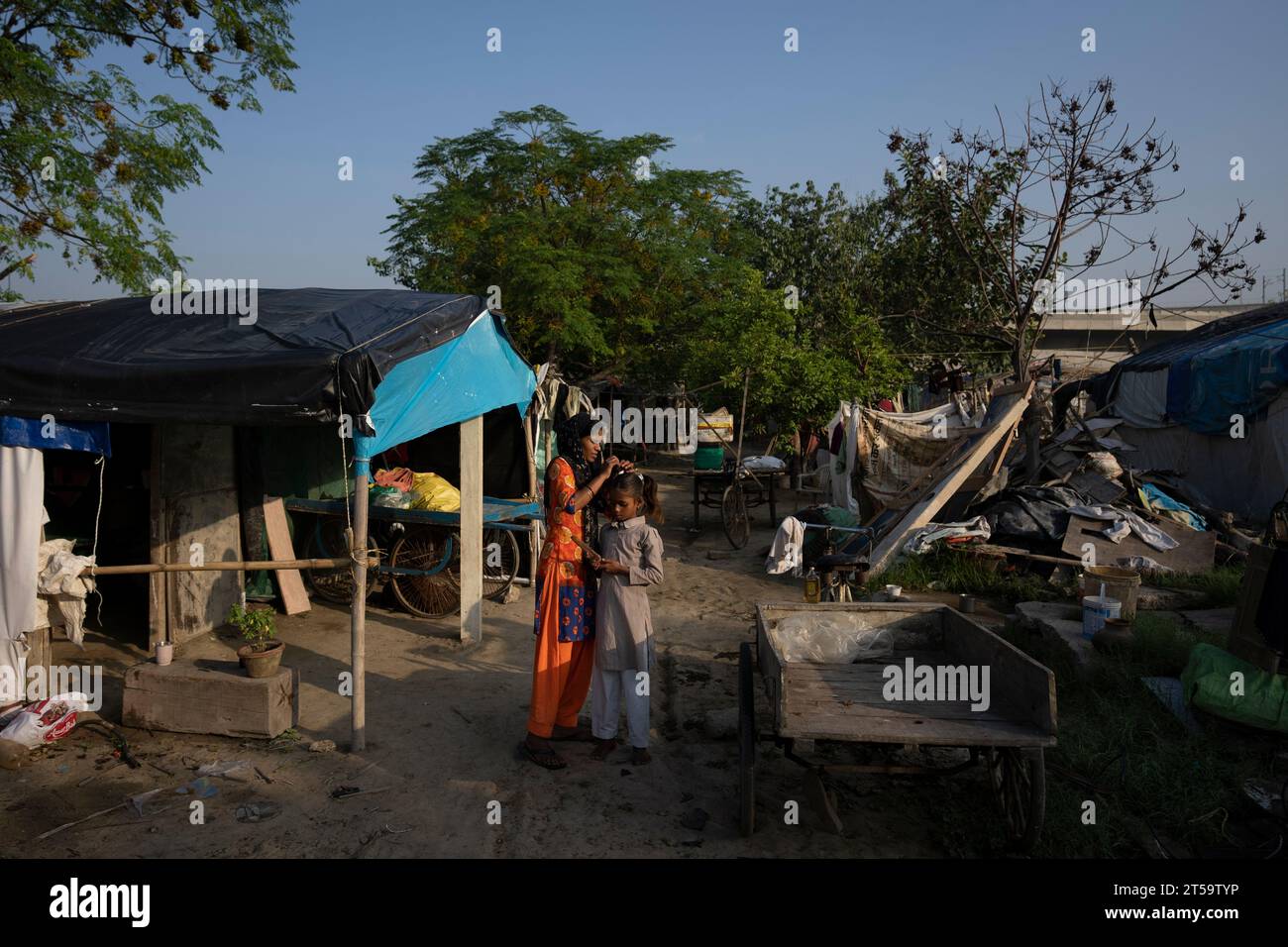 Meera Devi, left, brushes her daughter's hair Garima, 10, as she ...