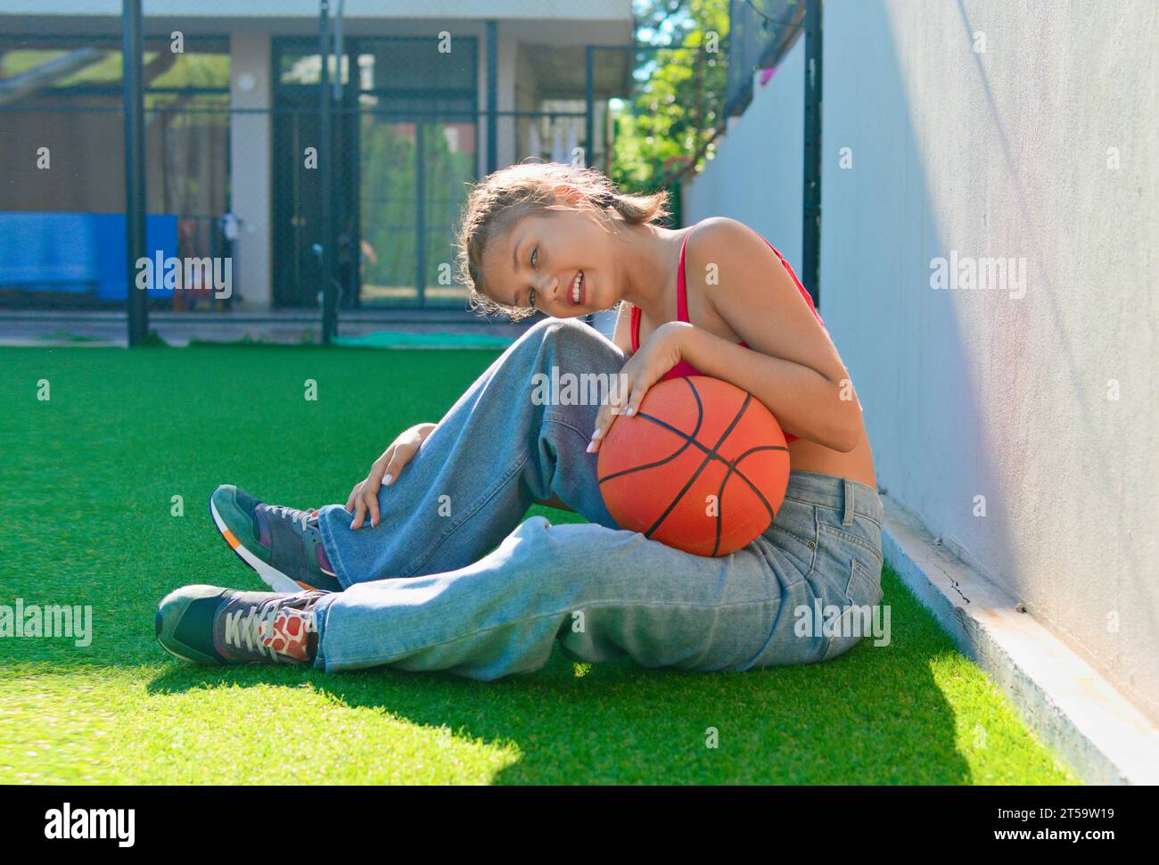Girl sitting on basketball hi-res stock photography and images - Alamy