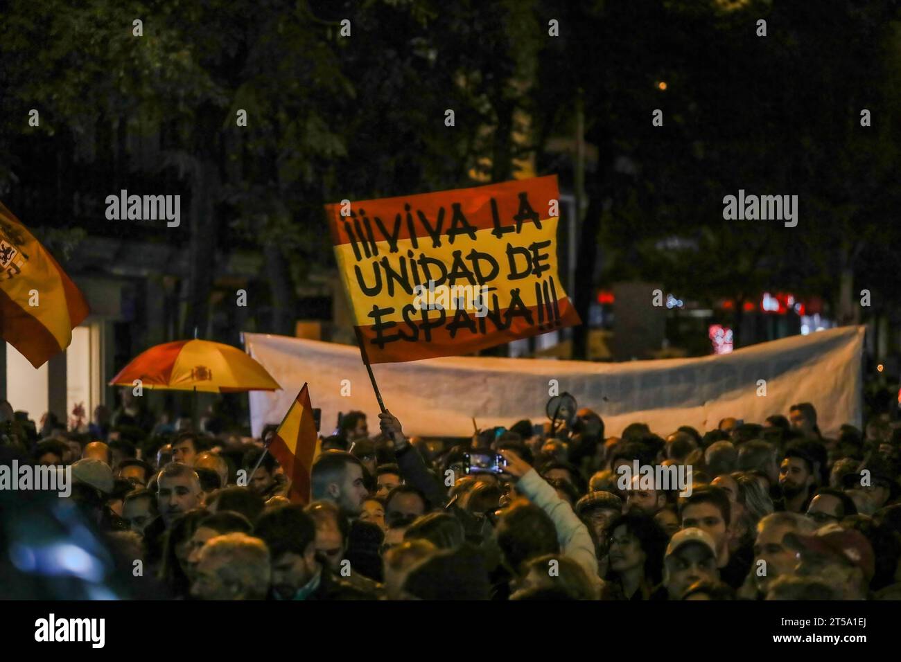 Protesters hold a Spanish flag with messages for the unity of Spain and ...