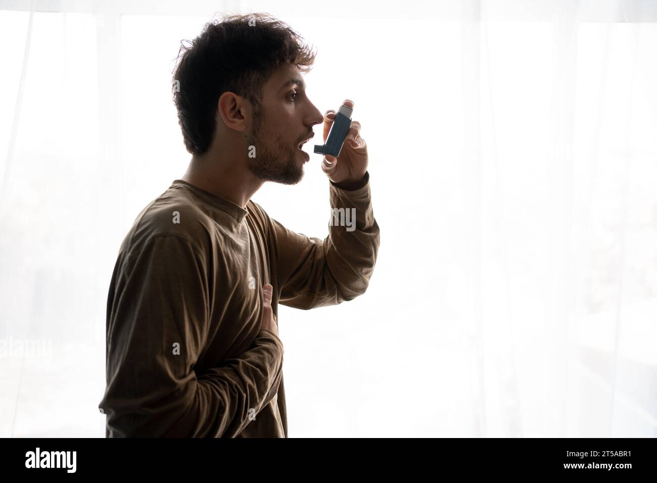 Indian guy suffering from asthma, Young man having asthma using the ...