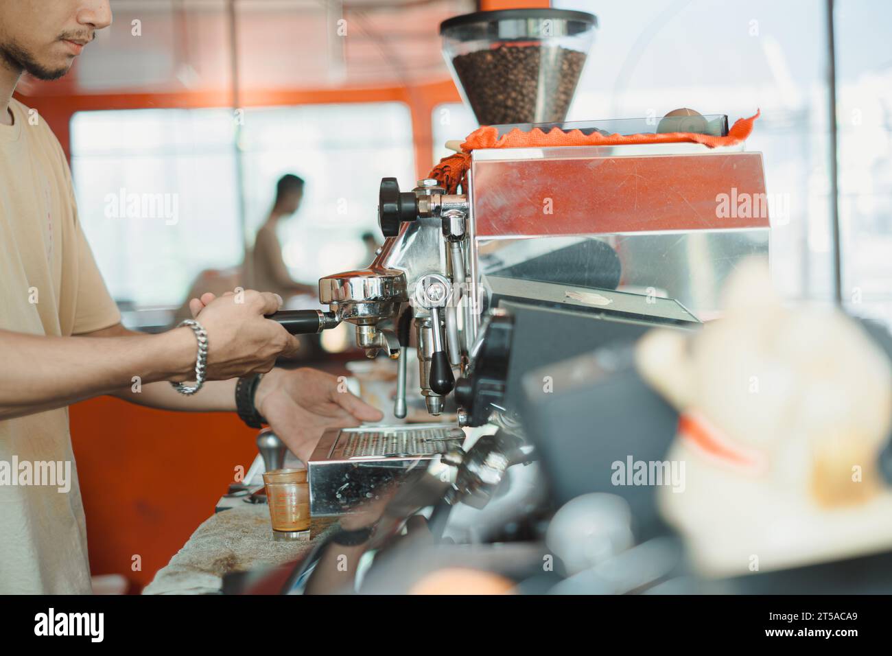 An Asian man is brewing a coffee using automatic espresso maker machine ...