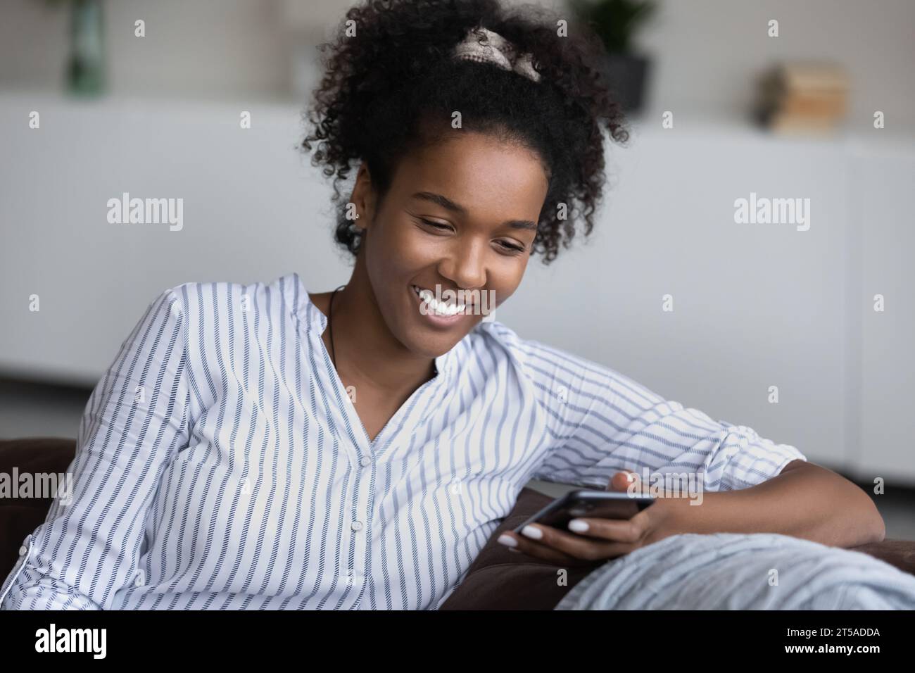 Happy Black girl, young woman relaxing on sofa Stock Photo - Alamy