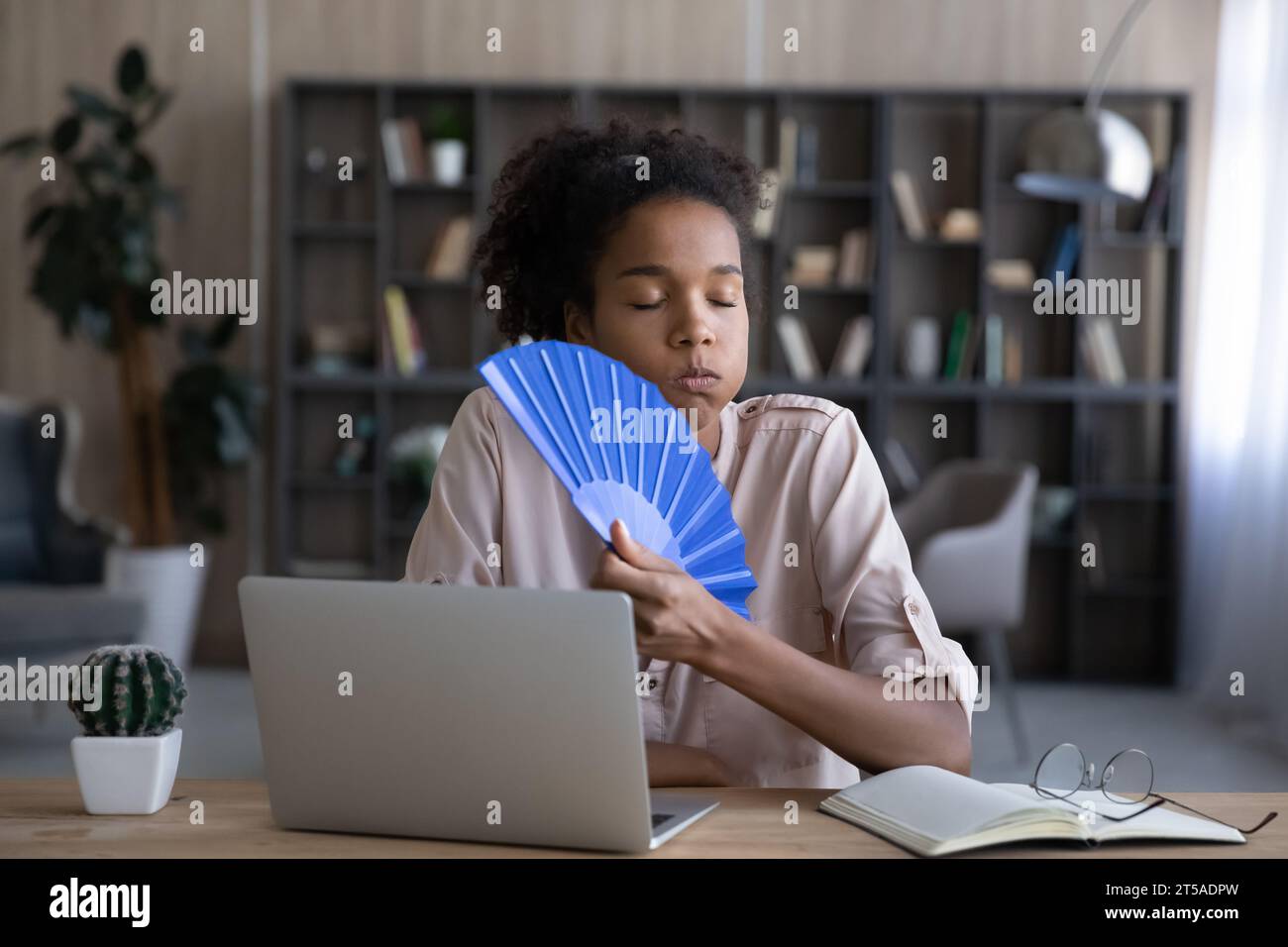 Exhausted African remote employee, student girl suffering from heat ...