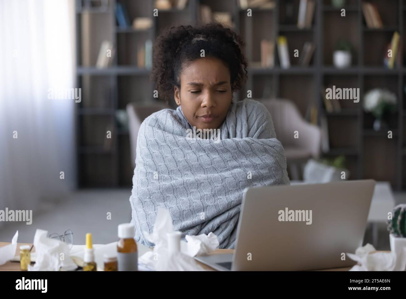 Frustrated ill young Black remote patient wrapped in warm plaid Stock ...