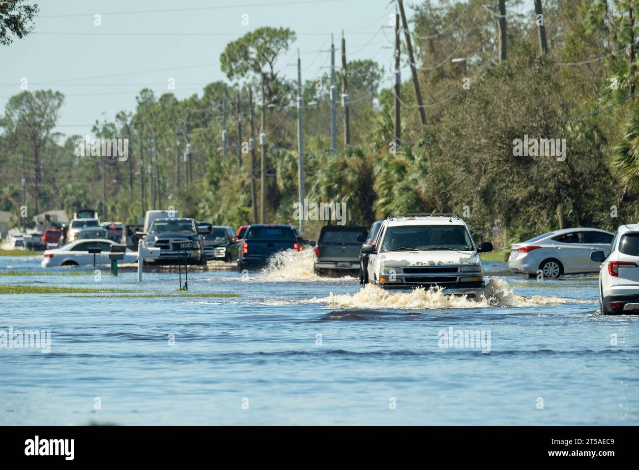 Hurricane flooded street with moving cars and surrounded with water ...