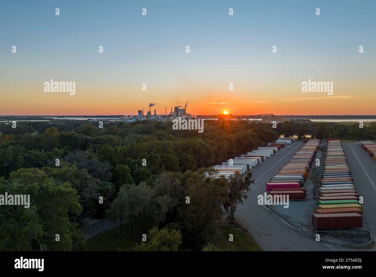 Large cargo container yard with many freight containers and big factory ...