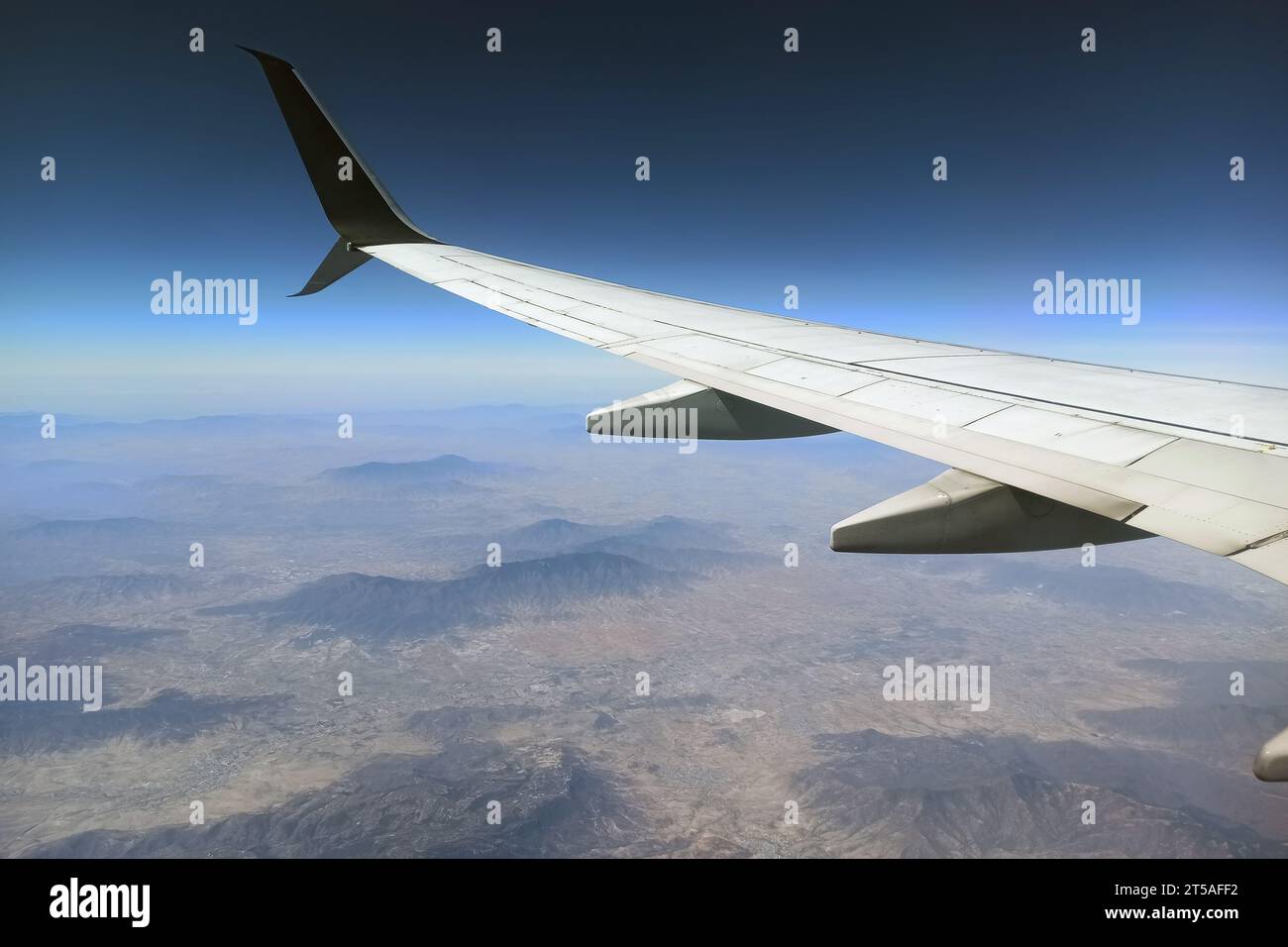 View through airplane window of commercial jet plane wing flying high ...