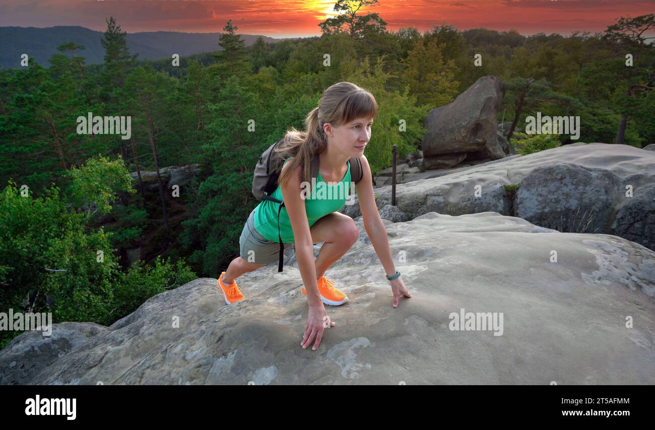 Young woman climbing alone on rocky mountain path. Female hiker ...