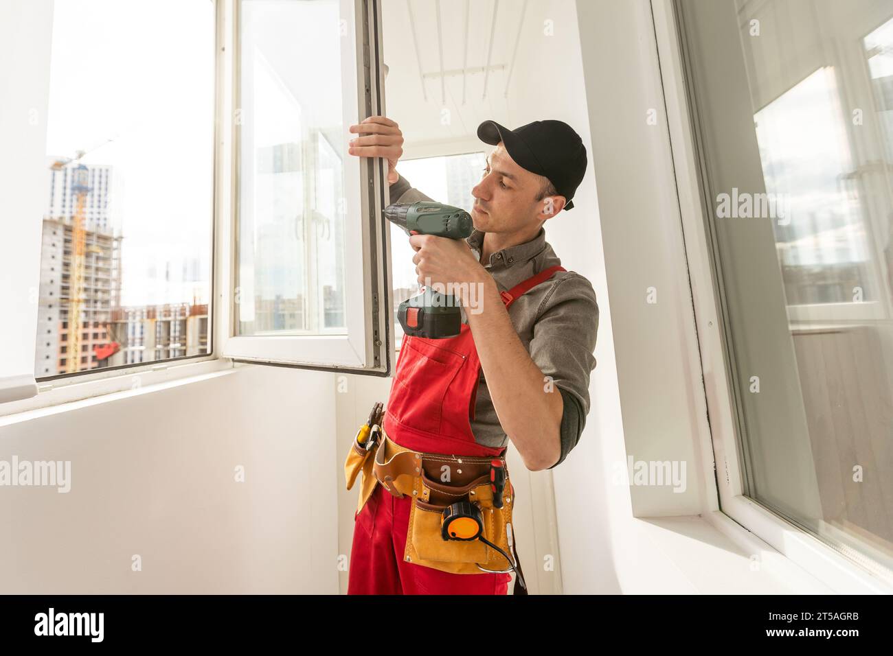 service man installing window with screwdriver Stock Photo - Alamy