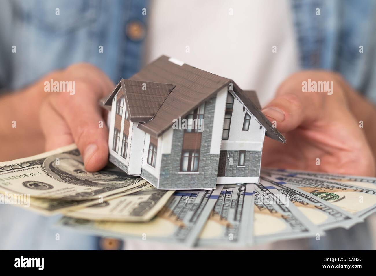 Business people holding banknotes There is a gray roof house in the ...