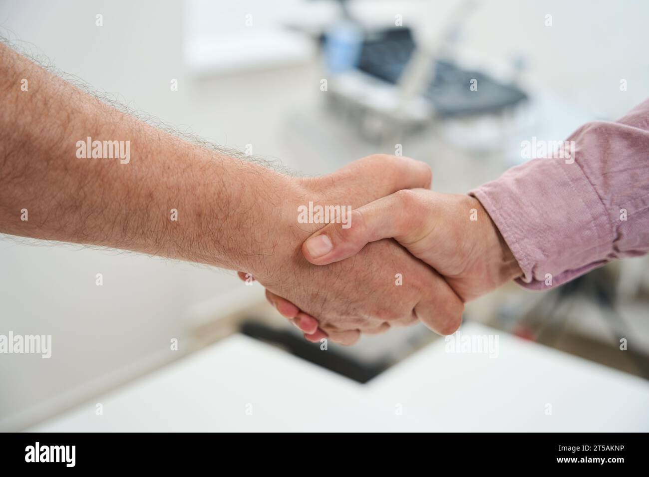 Adult men shake hands in greeting Stock Photo - Alamy