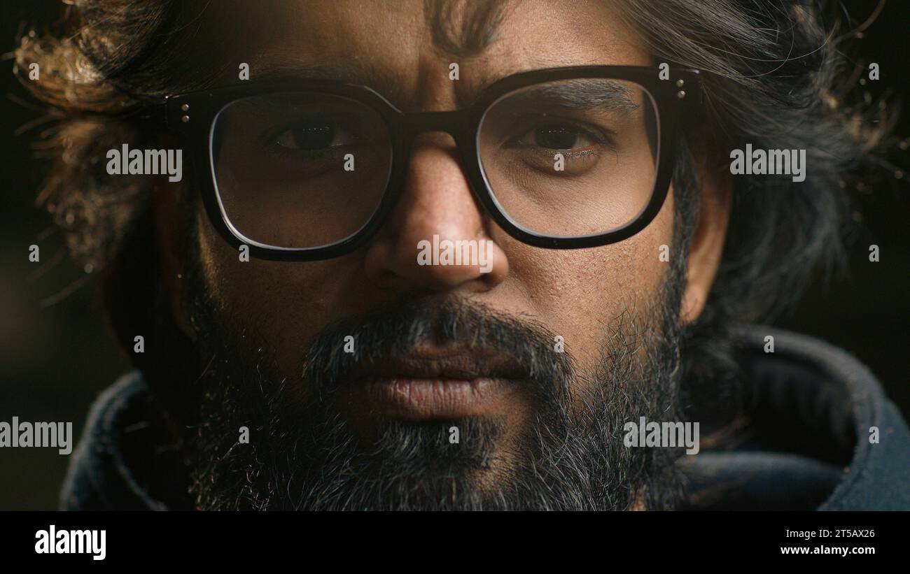 Extreme close up serious calm Arabian male face in eyeglasses looking ...