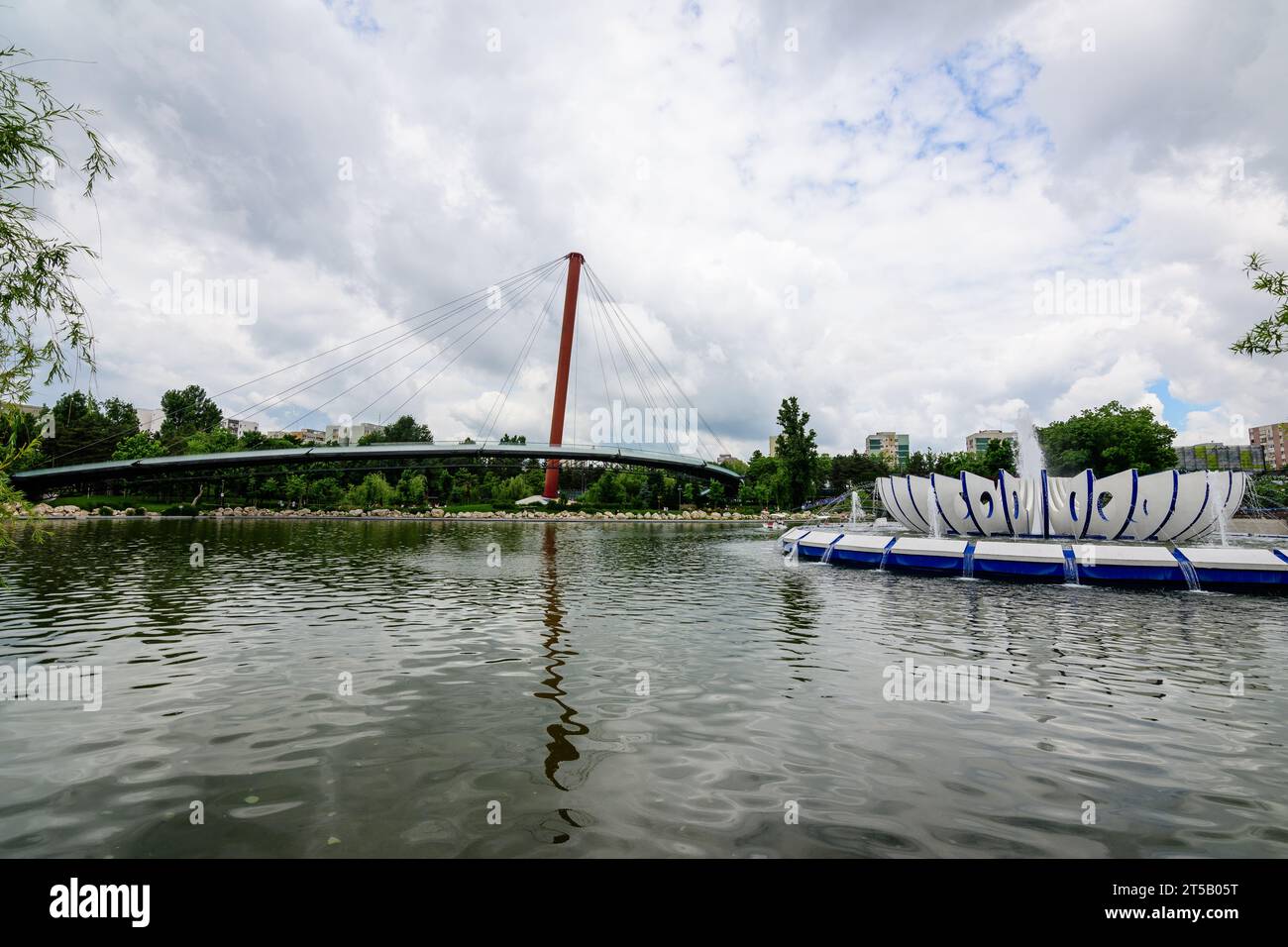 Landscape with the lake, decorative fountain and vivid green trees in ...