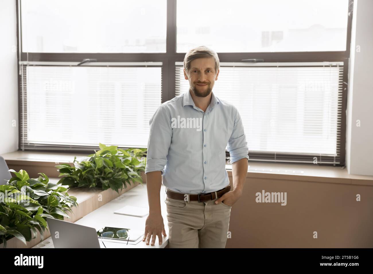 Positive Caucasian business owner man standing at office desk Stock ...