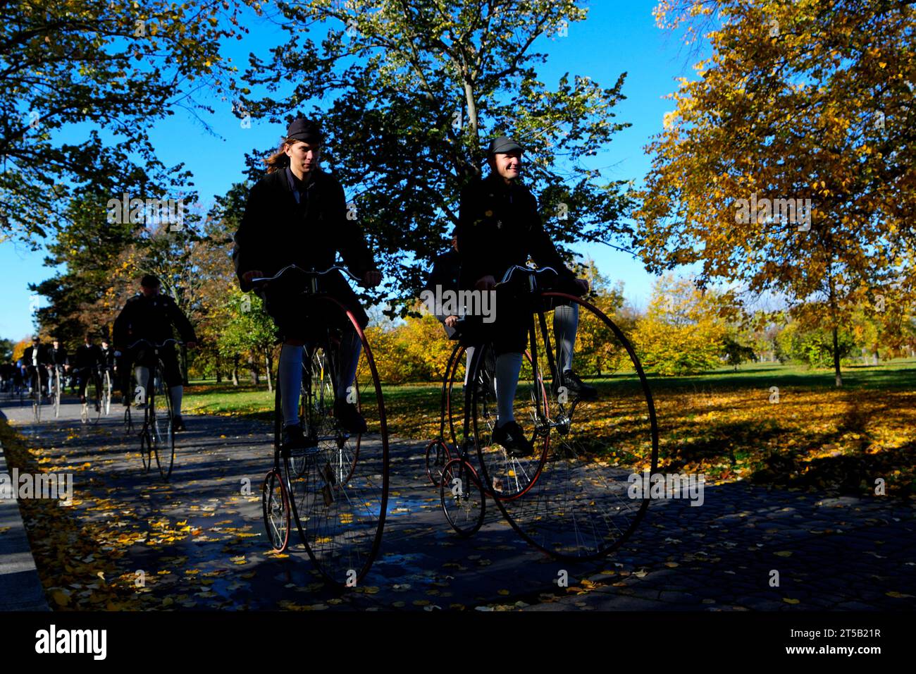 Enthusiasts dressed in historical costumes enjoy a ride on their penny ...