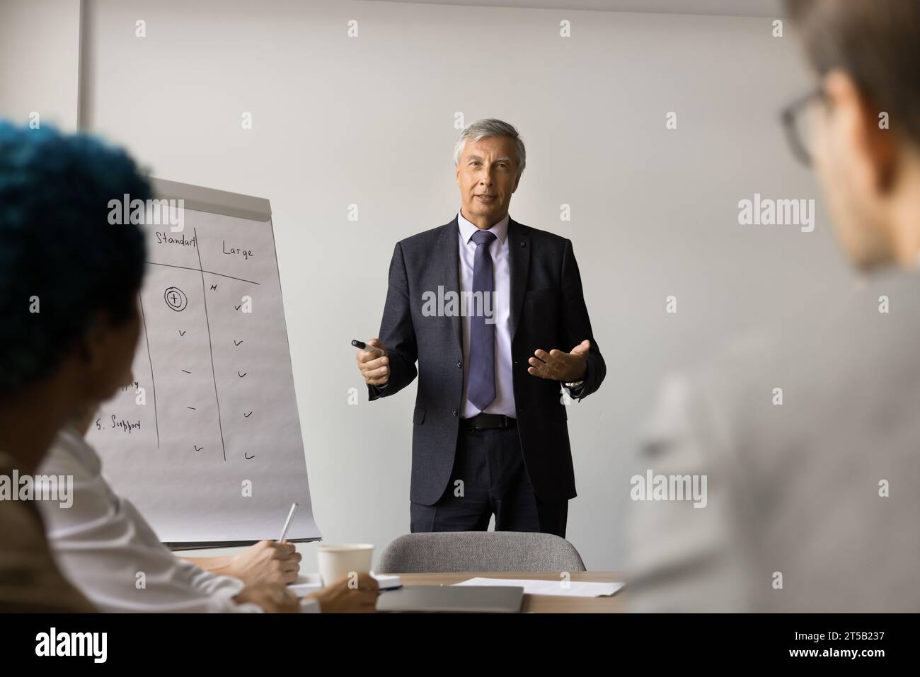 Successful elder business teacher man training multiethnic younger ...