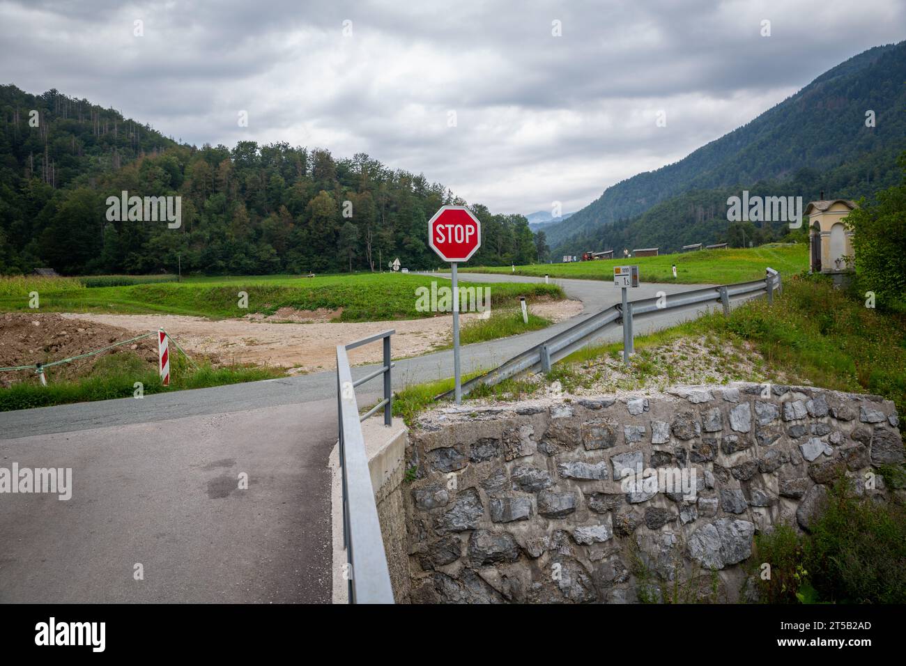 Stop sign stands on an empty way that passes through a rural landscape ...