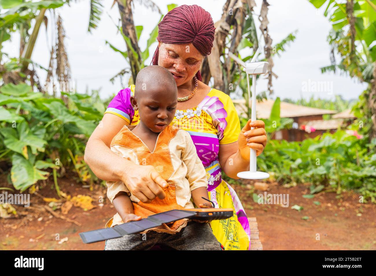 In one hand the mother holds the wind turbine and with the other shows ...