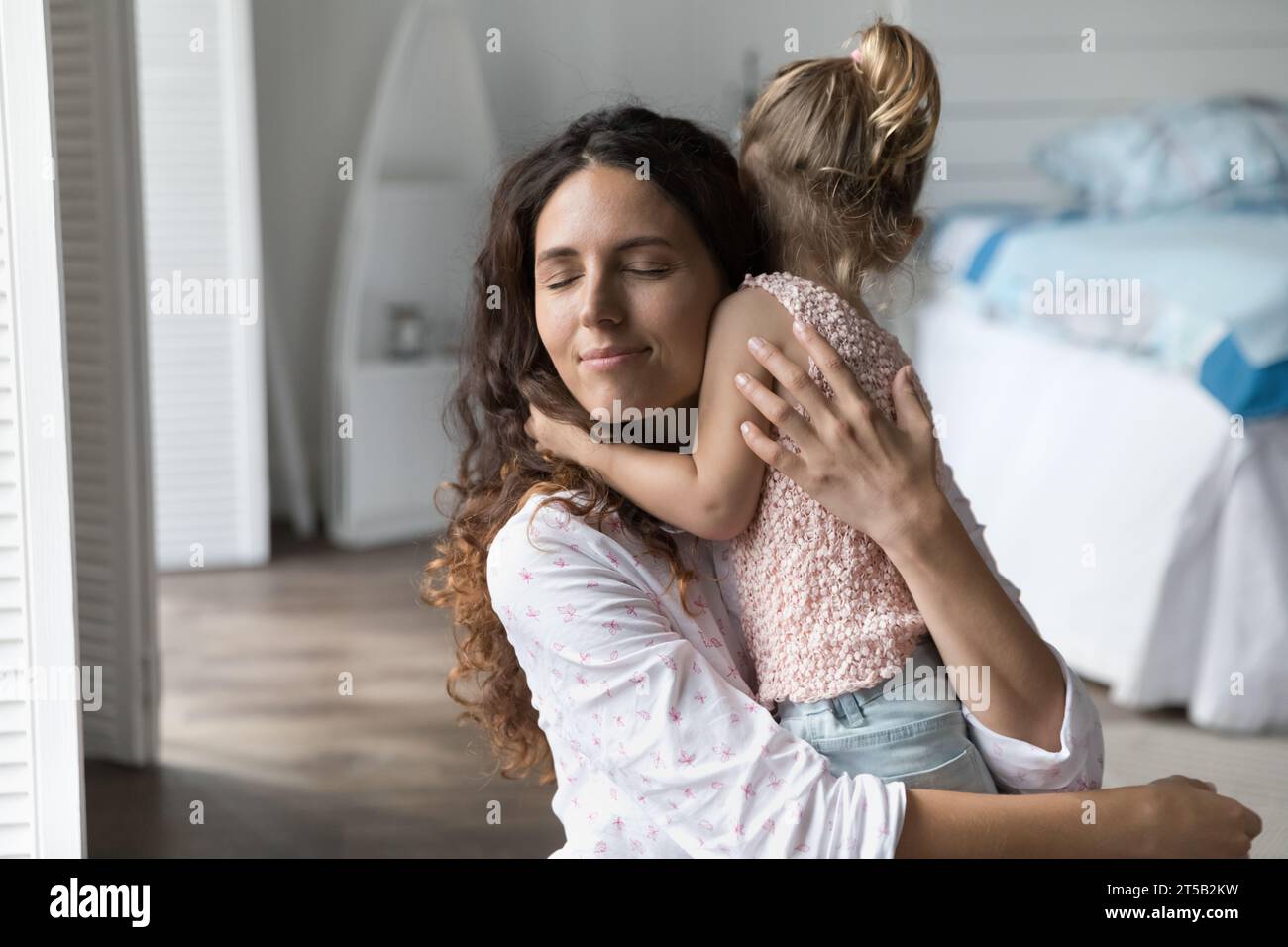 Young loving mother gently hugging her little daughter Stock Photo - Alamy