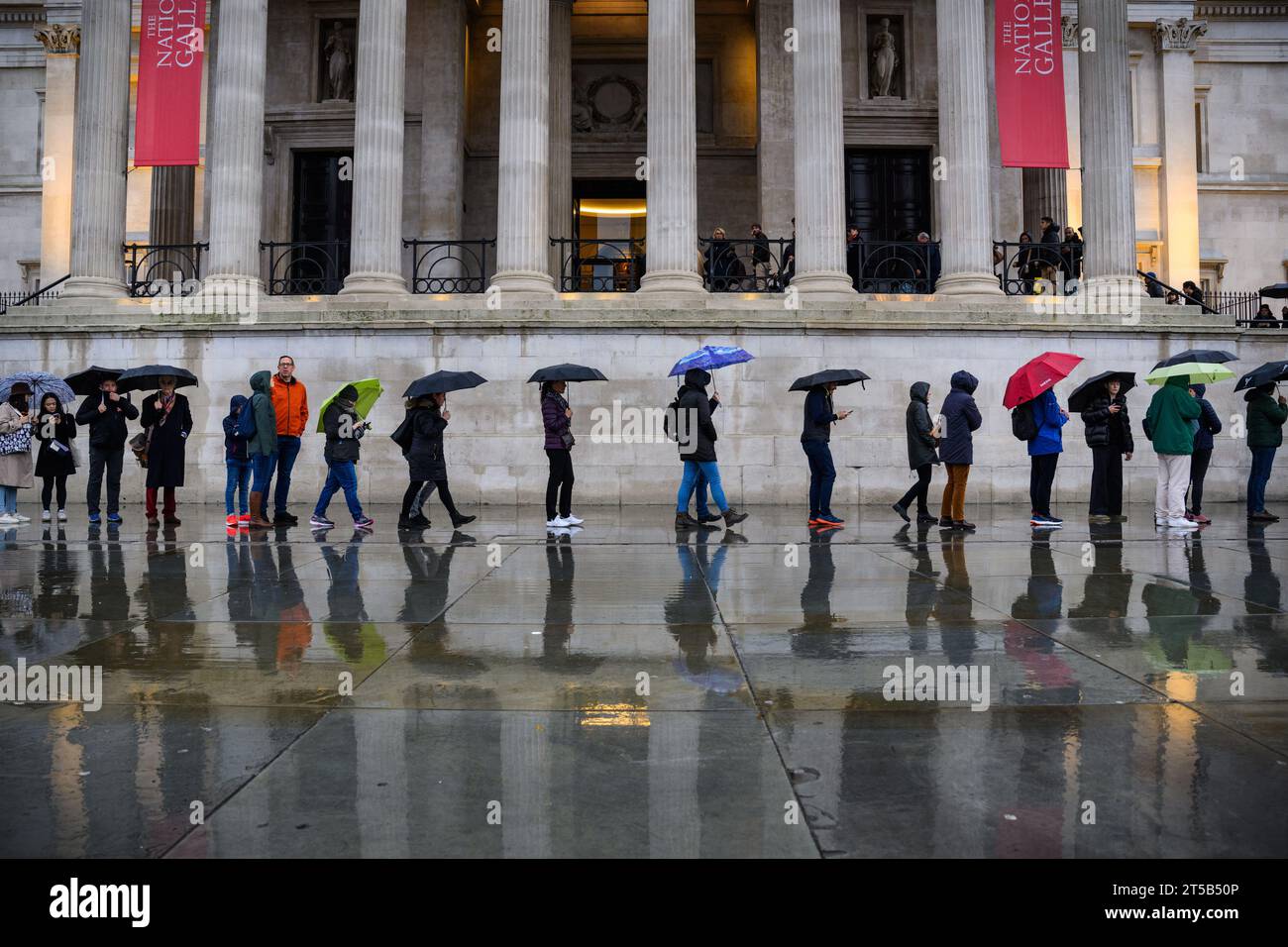 People with umbrellas in the wet weather in Trafalgar Square, London ...