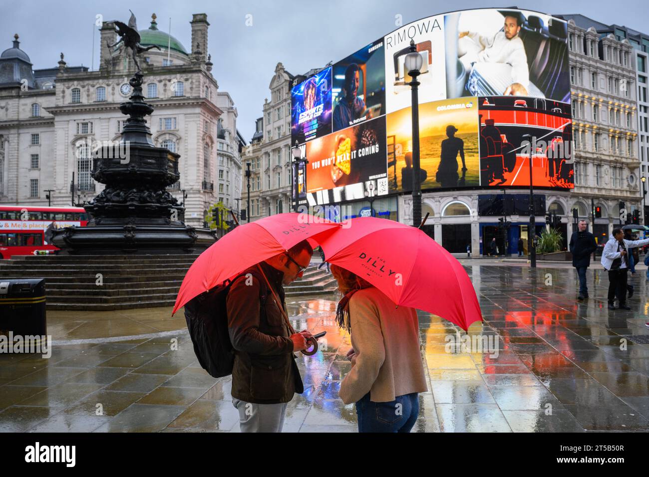 People with umbrellas in the wet weather in Piccadilly Circus, London ...