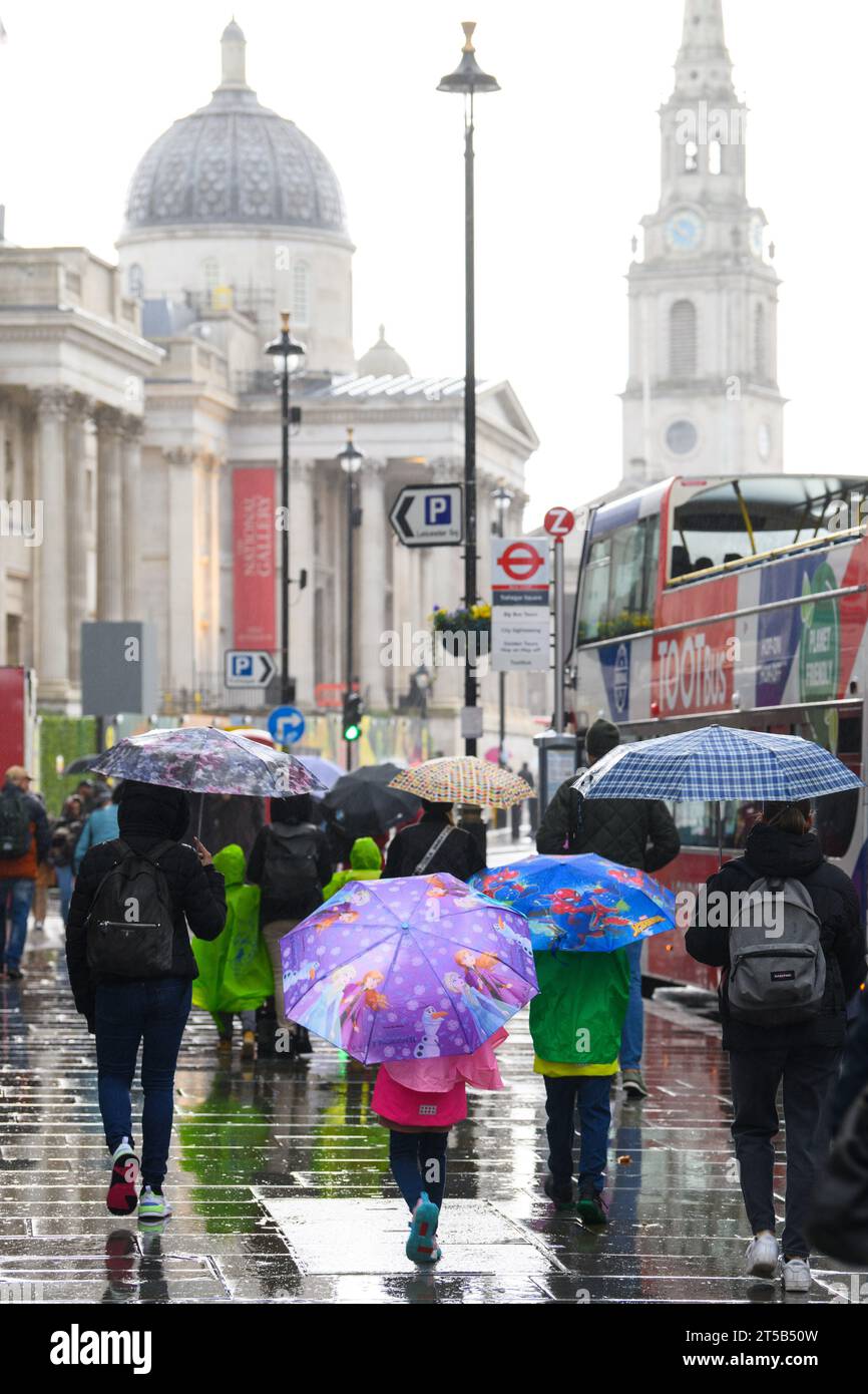 People with umbrellas in the wet weather in Trafalgar Square, London ...