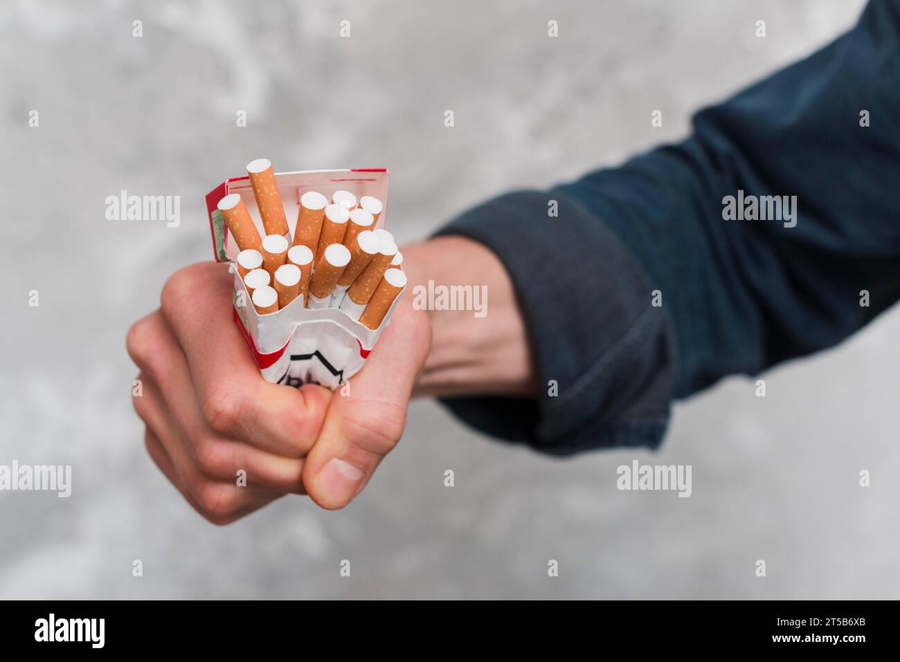 Close up man s hand crushing cigarettes box Stock Photo - Alamy