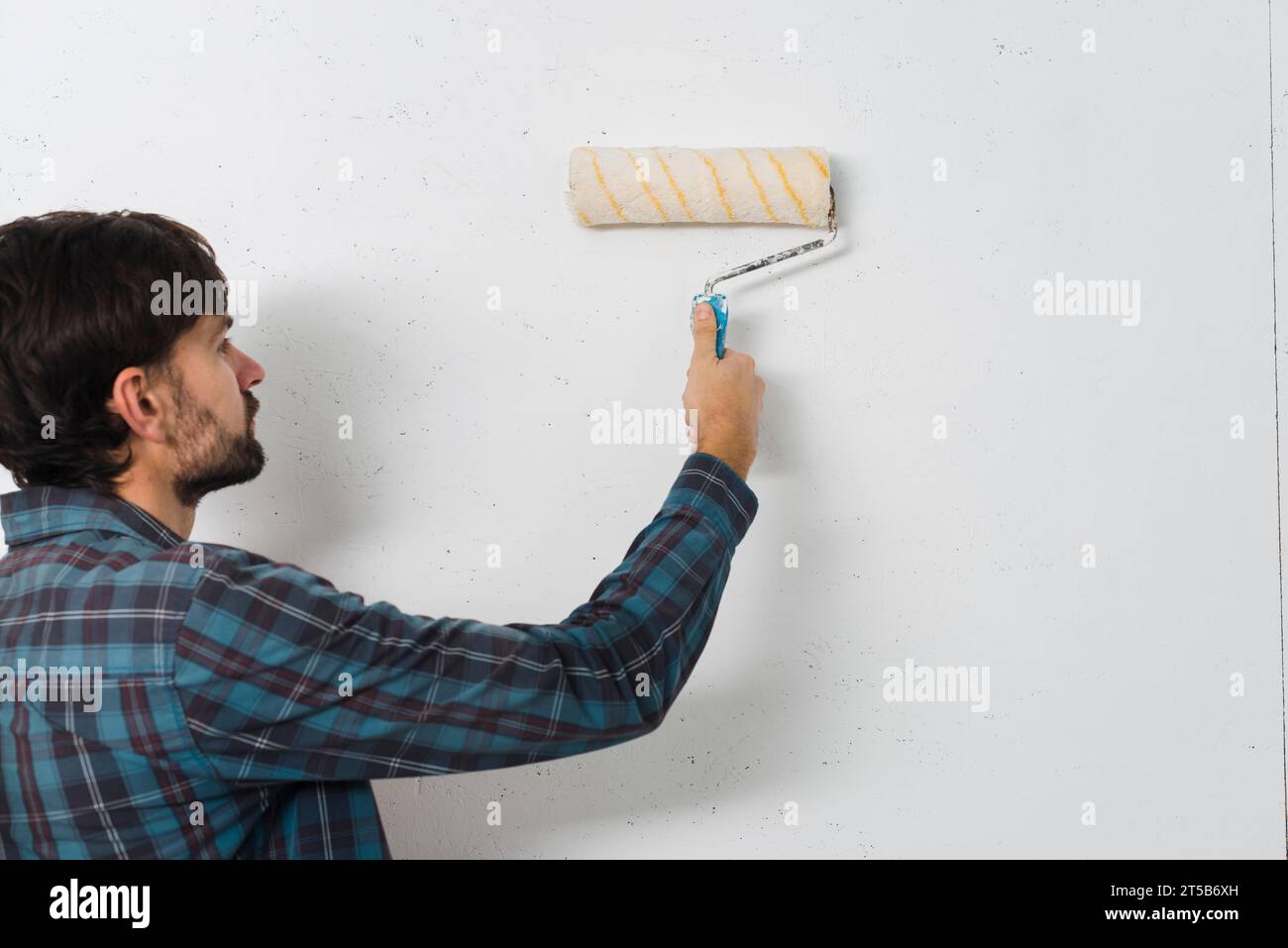 Close up man painting wall with paint roller Stock Photo - Alamy