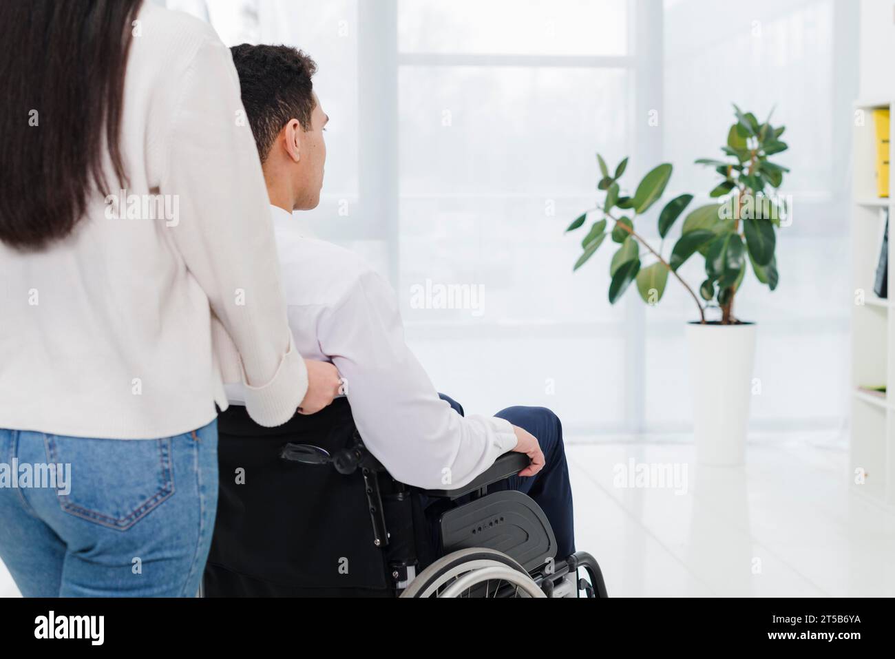 Close up man pushing woman wheelchair Stock Photo - Alamy