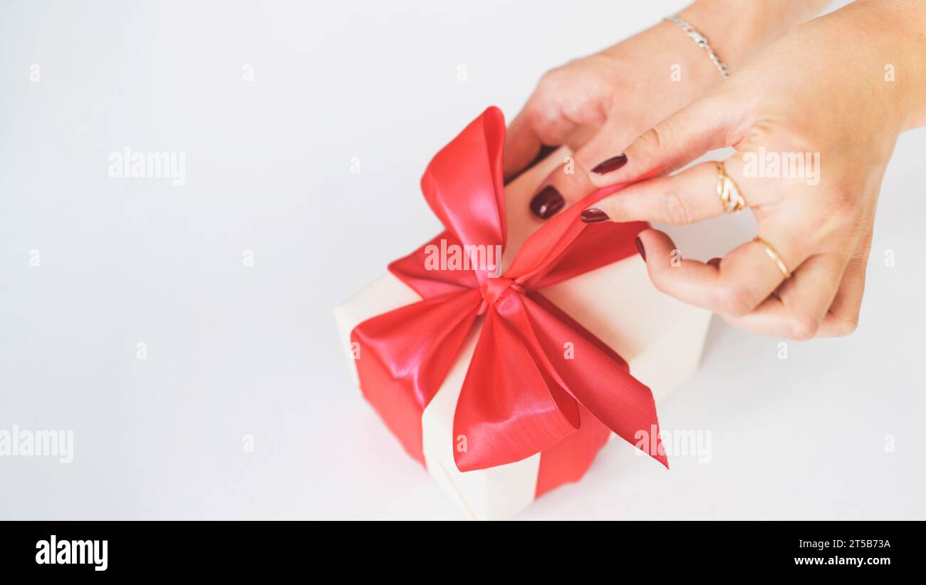 Close up woman s hand unwrapping gift box white background Stock Photo ...