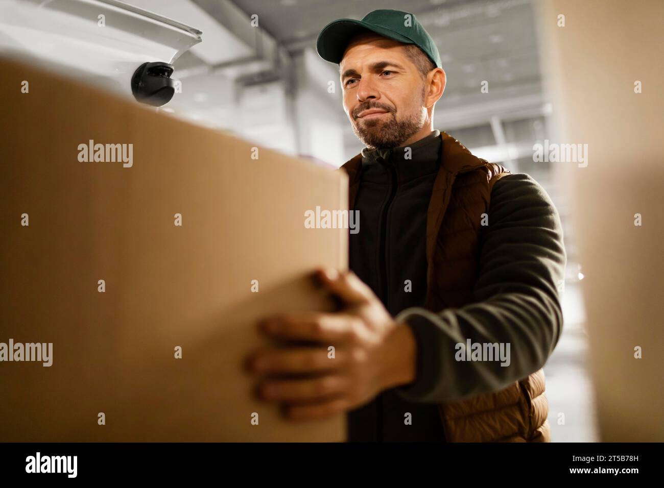 Delivery man with package Stock Photo - Alamy