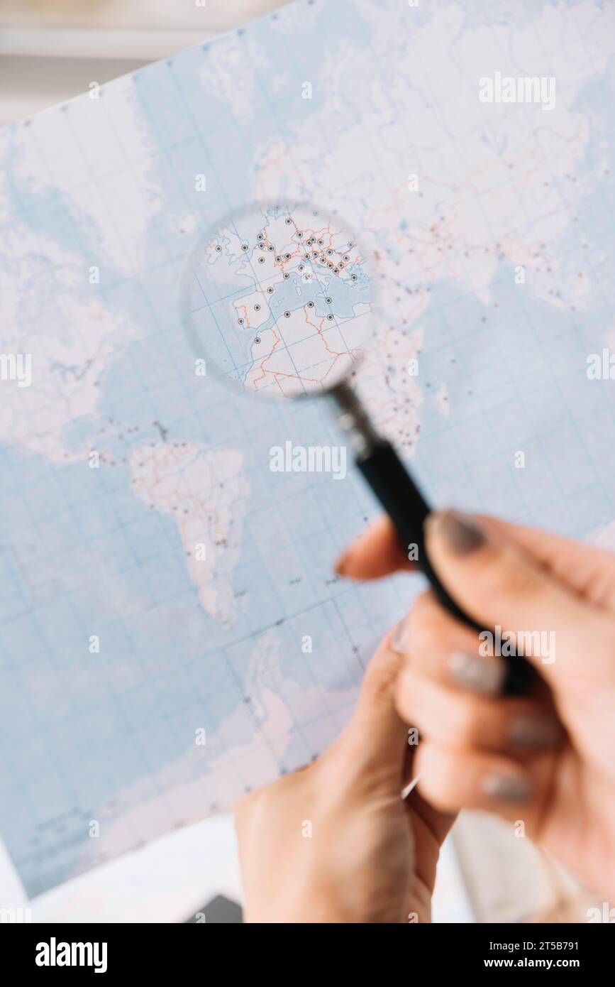 Female tourist searching places travel map through magnifying glass ...