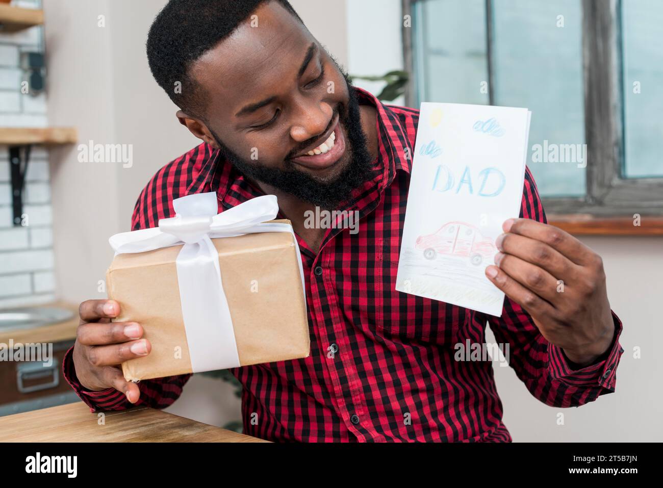 Happy black man holding greeting card gift Stock Photo - Alamy
