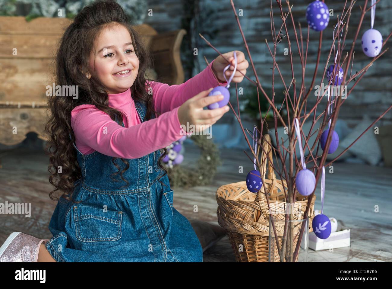 Happy girl hanging easter eggs branch Stock Photo - Alamy