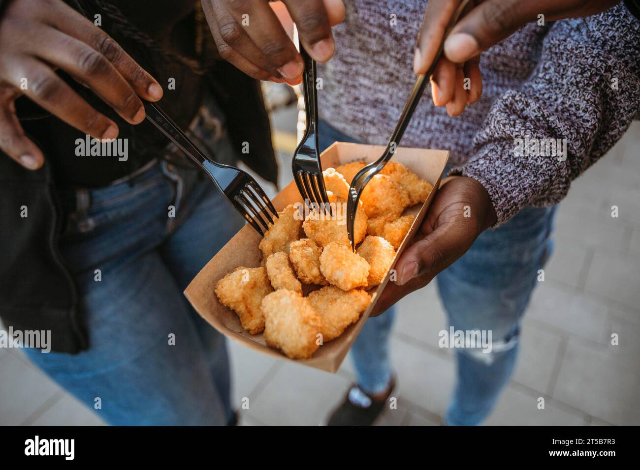 High angle people eating nuggets out takeout packaging Stock Photo - Alamy