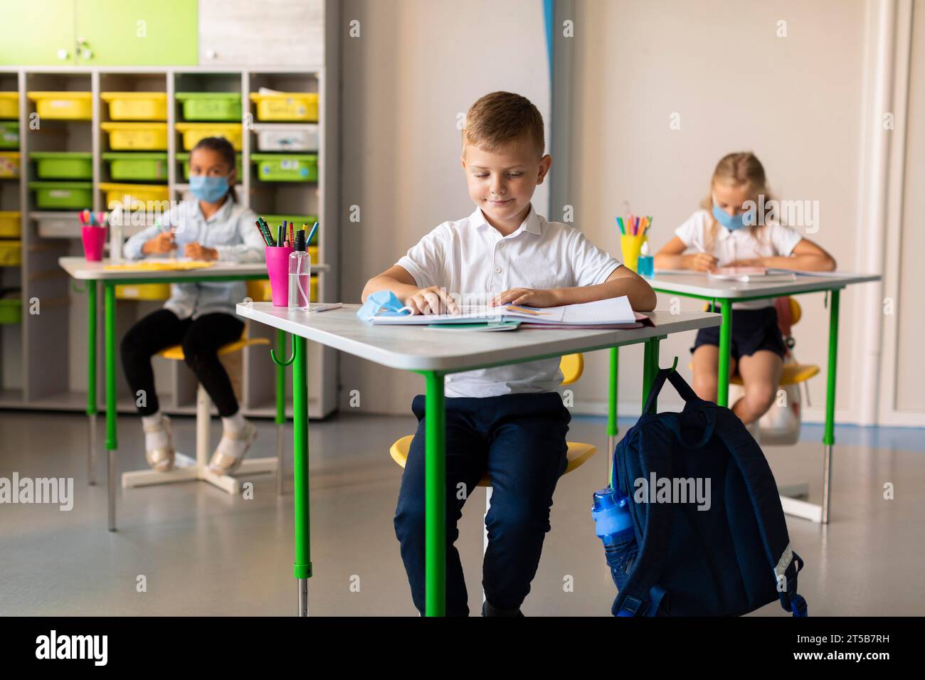 Kids keeping social distance classroom Stock Photo - Alamy