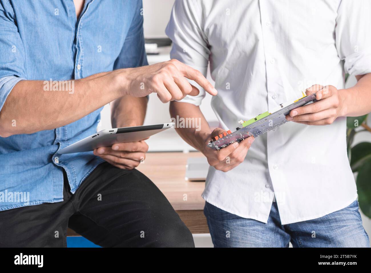 Man assisting male technician holding computer motherboard Stock Photo ...