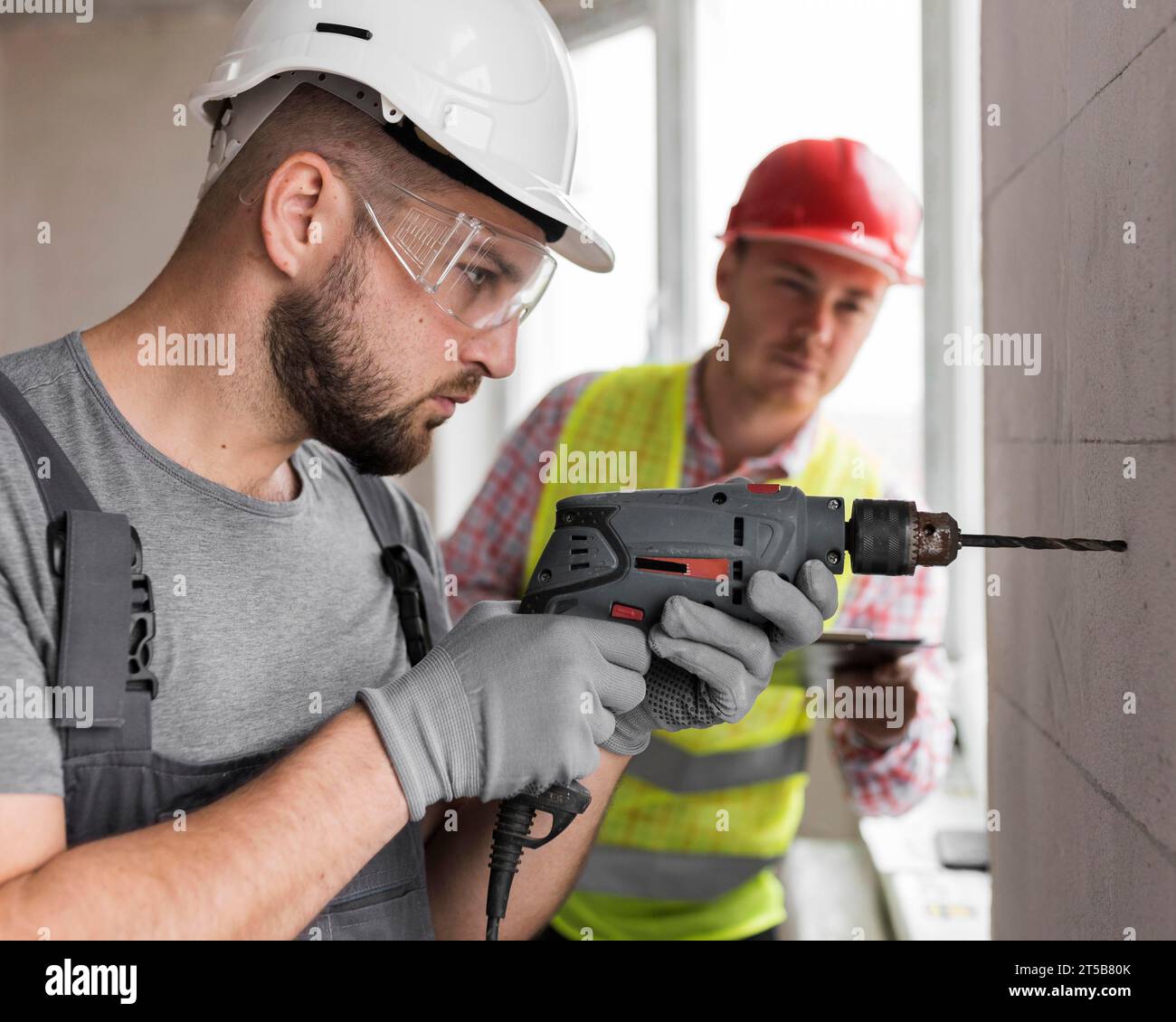 Medium shot man working with drill Stock Photo - Alamy