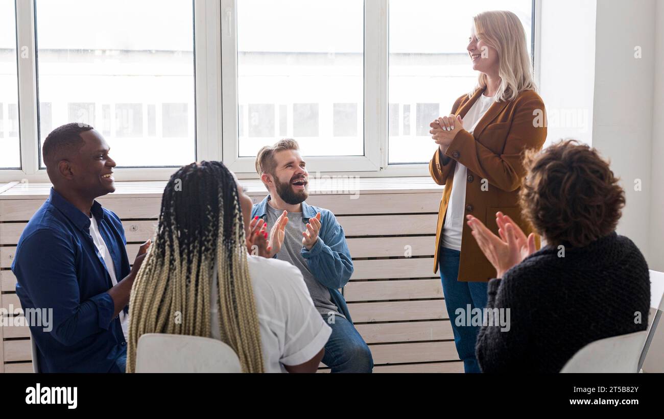Medium shot people clapping Stock Photo - Alamy
