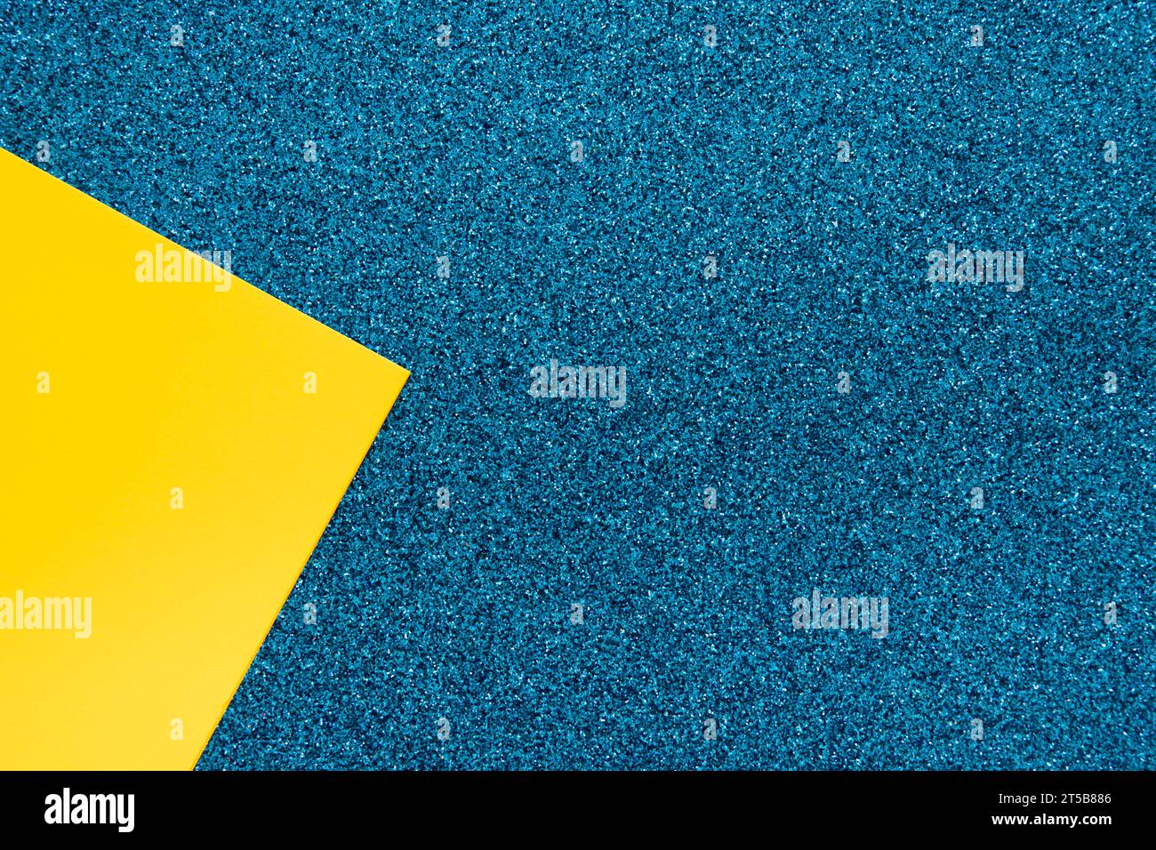 Overhead view yellow cardboard paper blue surface Stock Photo - Alamy