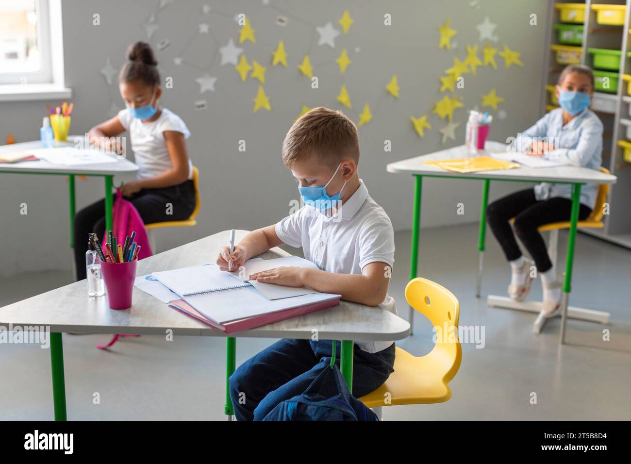 Side view kids taking notes class while wearing medical masks Stock ...