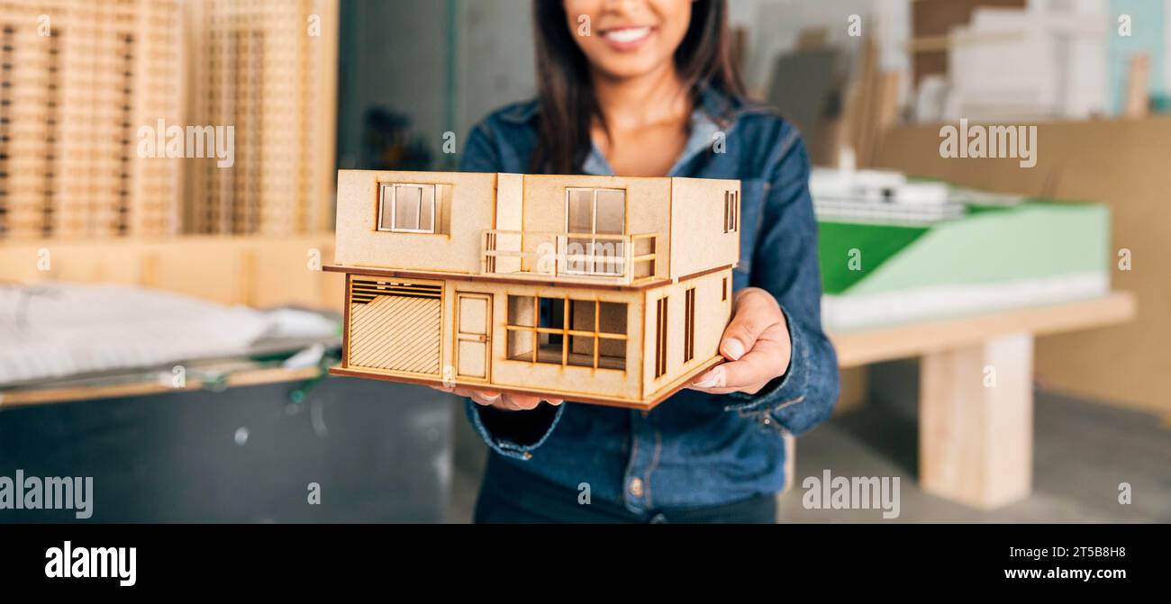 Smiling african american woman showing model house Stock Photo - Alamy