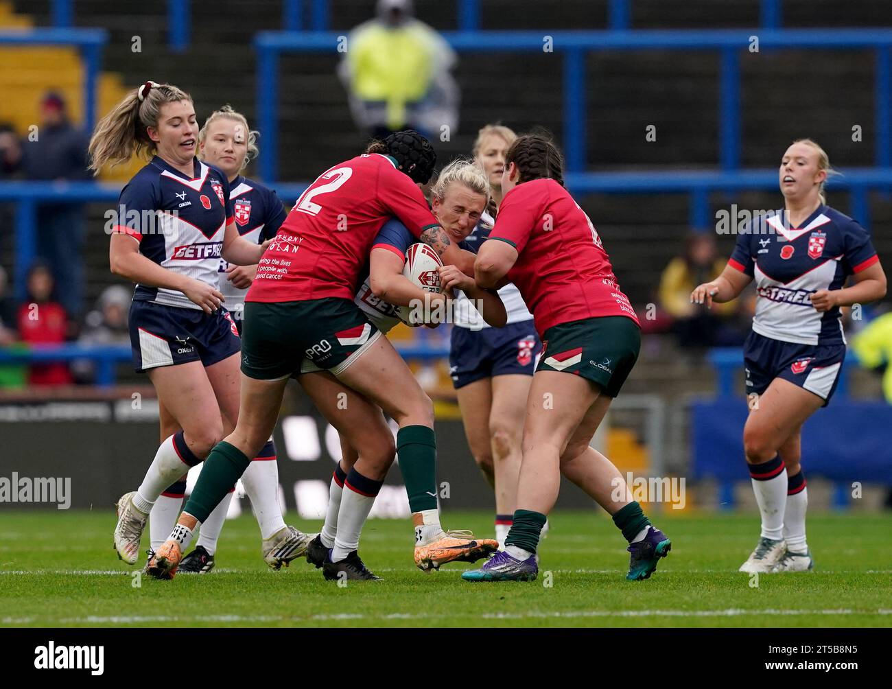 England's Jodie Cunningham (centre) is tackled by Wales' Charlie Mundy ...