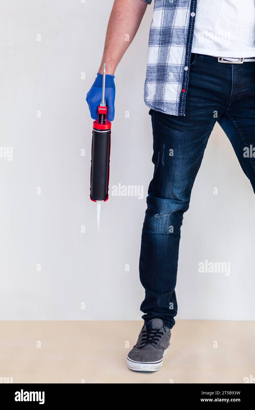 Worker holding silicone gun Stock Photo - Alamy