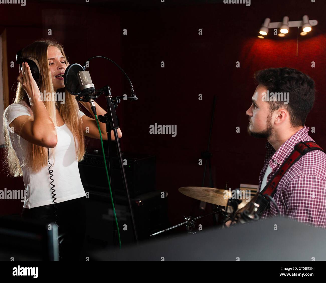 Woman singing microphone guy playing guitar Stock Photo - Alamy